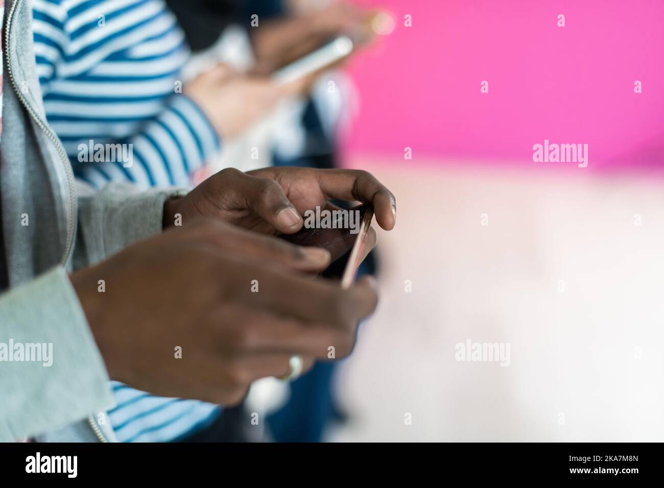 Diverse teenagers using mobile devices while posing for a studio photo ...