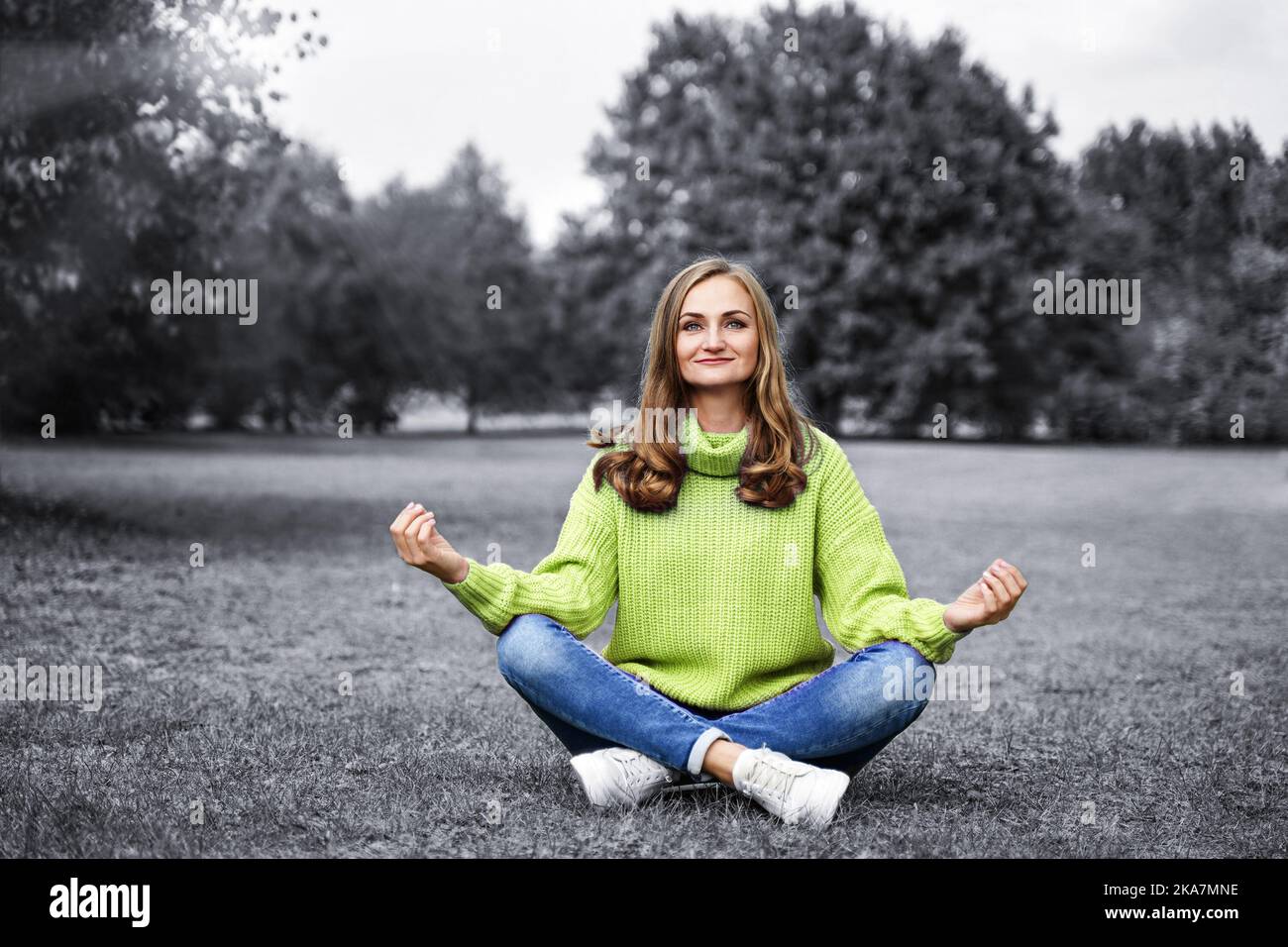 Woman sitting in the lotus position on the black and white background ...