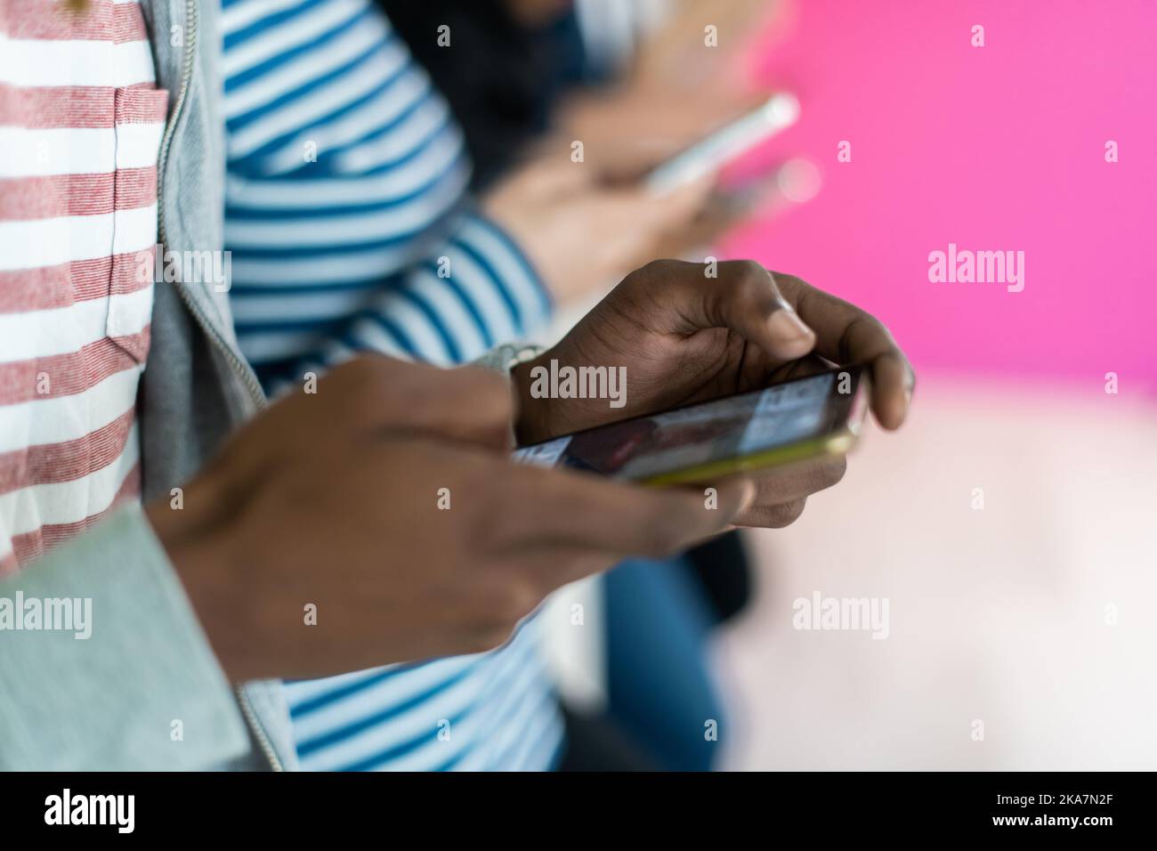 Diverse teenagers using mobile devices while posing for a studio photo ...