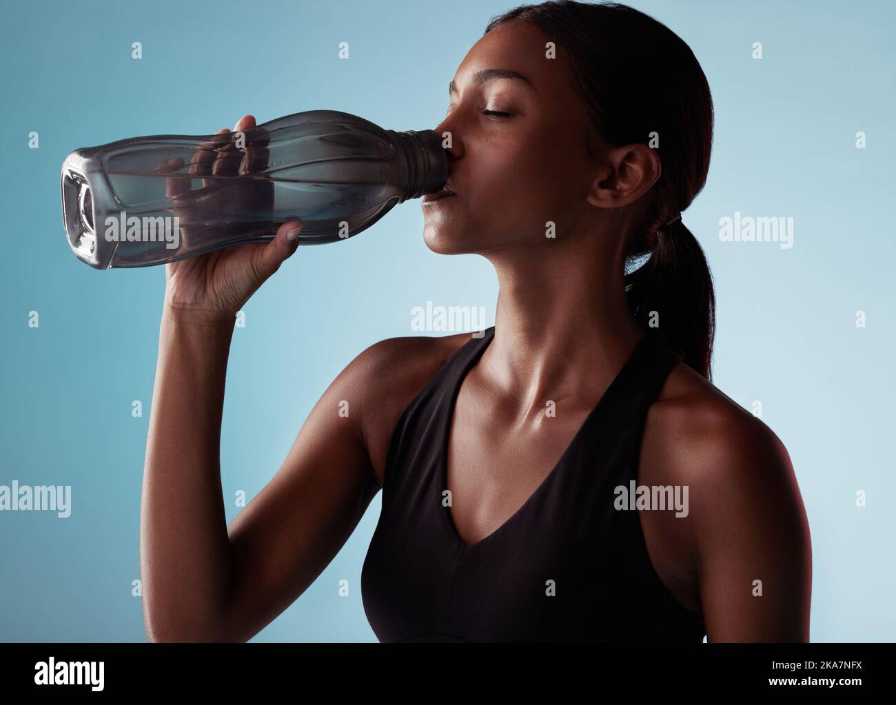 Fitness, sports and woman drinking water in studio for a healthy body ...