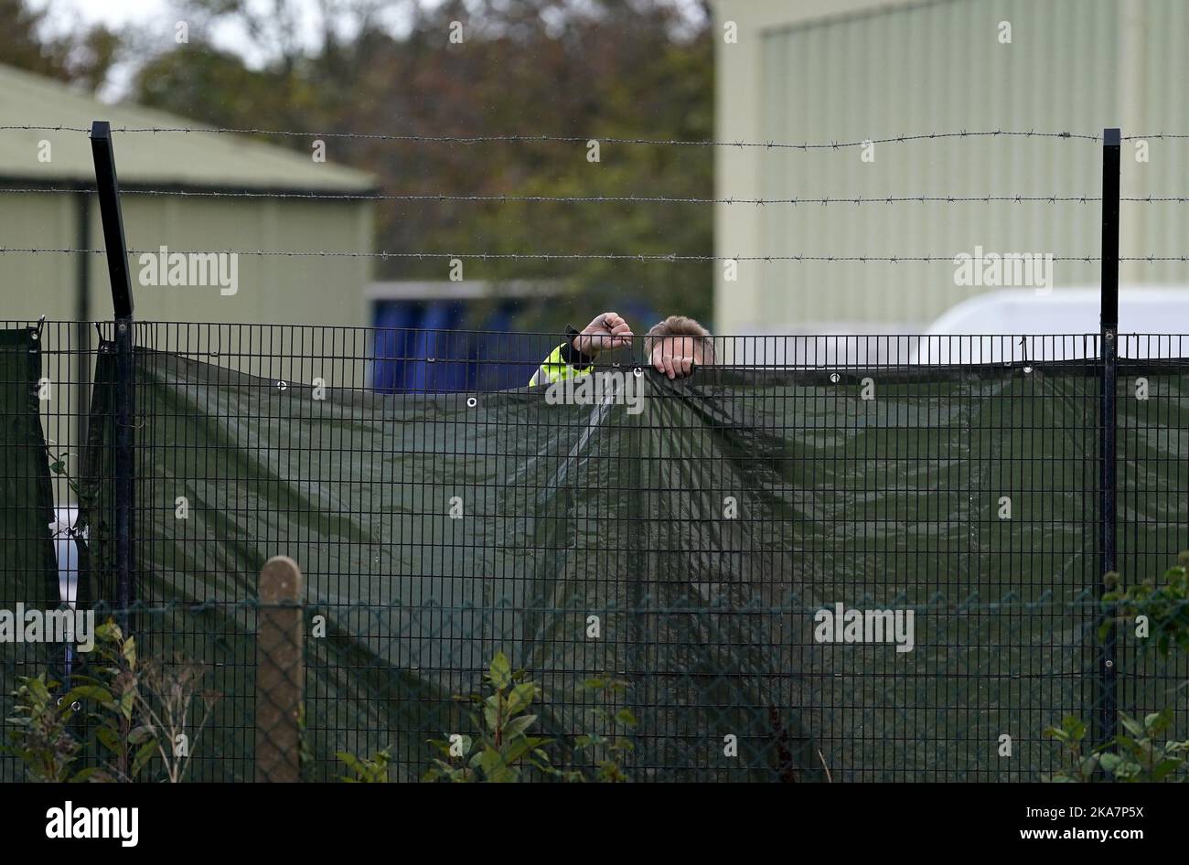 A member of security staff secures screens around the Manston ...