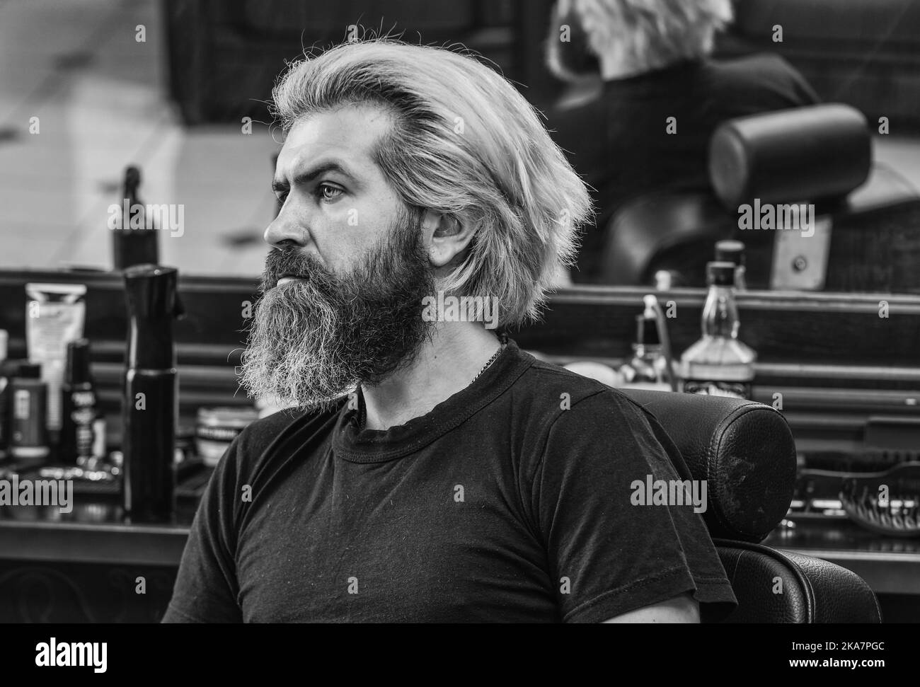 brutal bearded man at hairdresser salon with master, hair look Stock ...