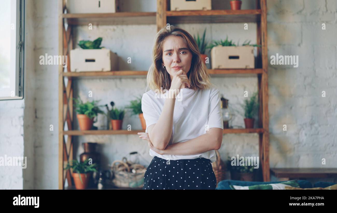 Portrait of upset young woman looking at camera and expressing negative ...
