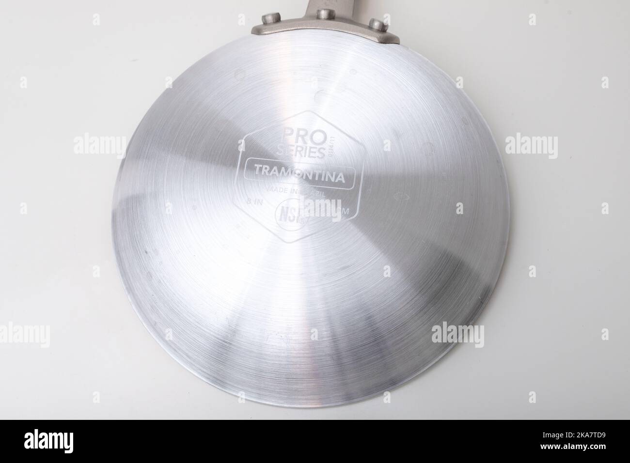 A stainless steel non-stick frying pan shot against a plain white ...