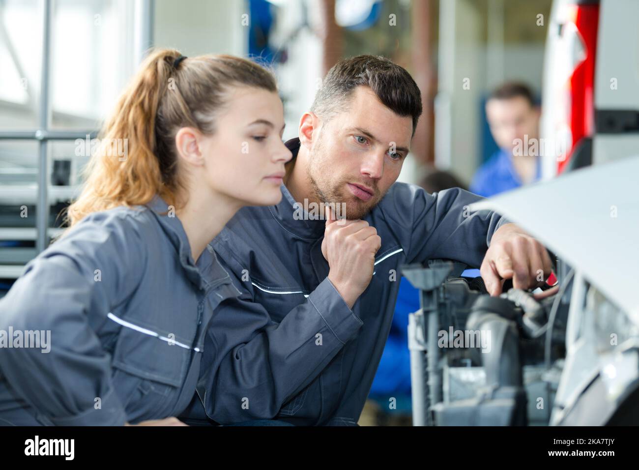 mechanic showing female trainee under the hood of the car Stock Photo ...