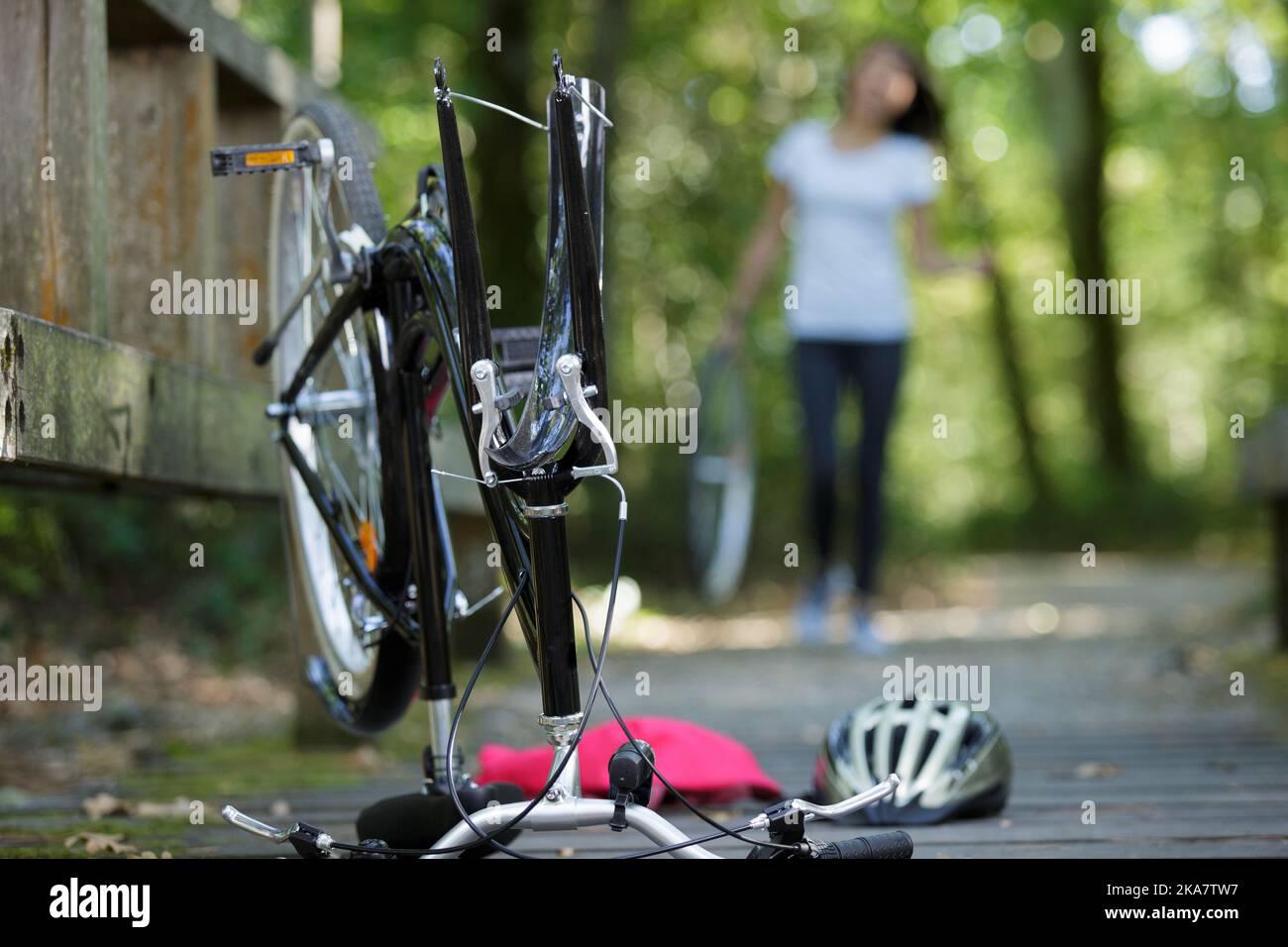 casual portrait of female has to fix her bike Stock Photo - Alamy