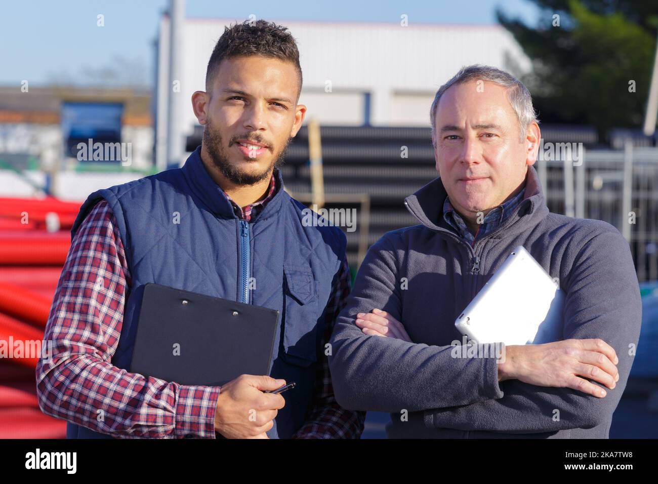 manager and worker with safety helmet outside a factory Stock Photo - Alamy