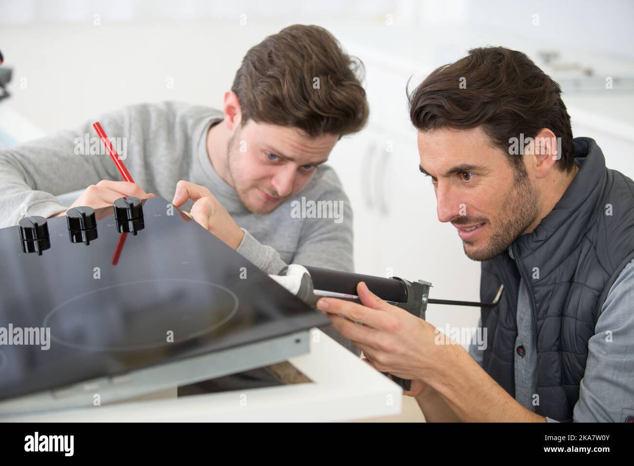 two men assembling a kitchen furniture Stock Photo - Alamy