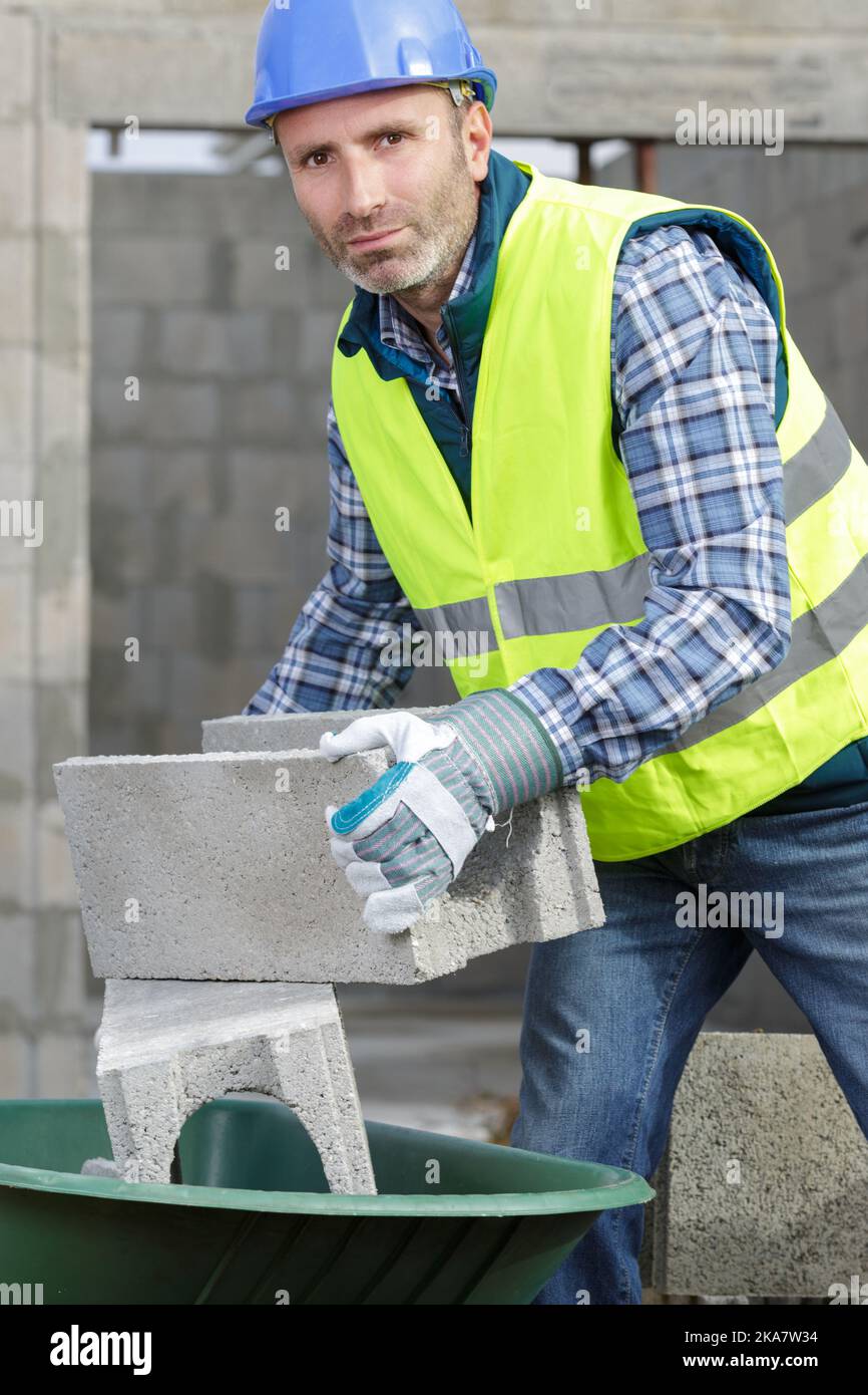 man builder carrying block cement Stock Photo - Alamy