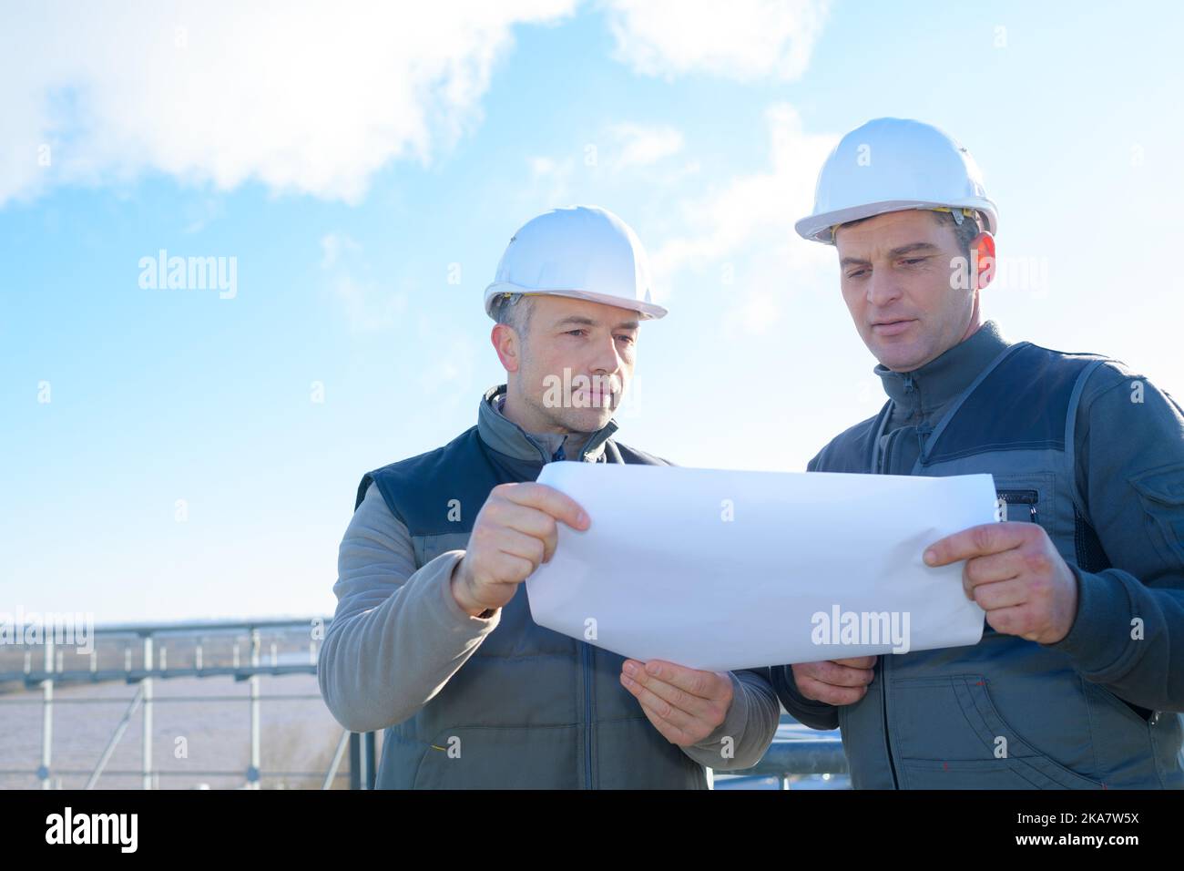 two engineers checking the architectural plan outdoors Stock Photo - Alamy