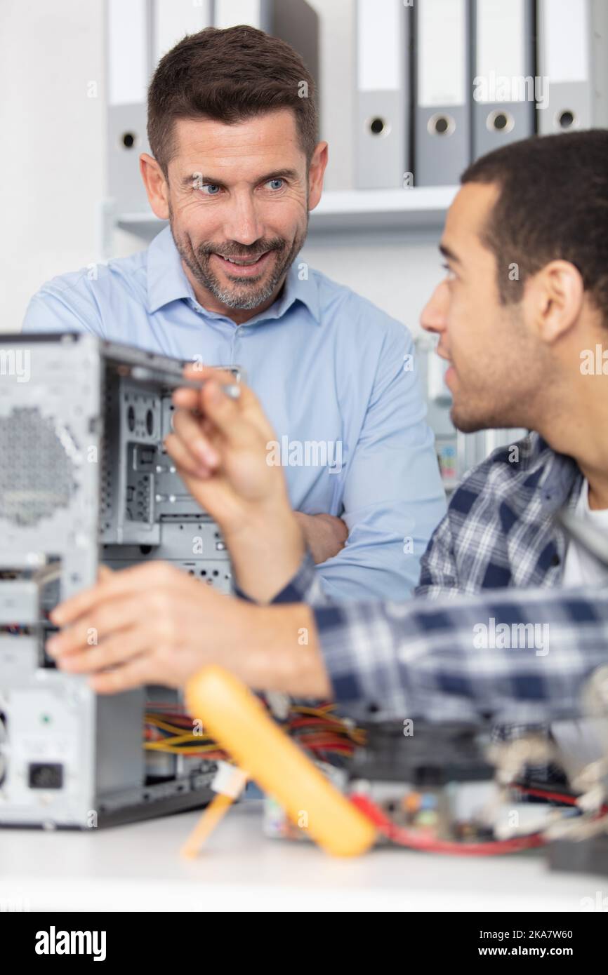 two it specialists are fixing a pc Stock Photo - Alamy