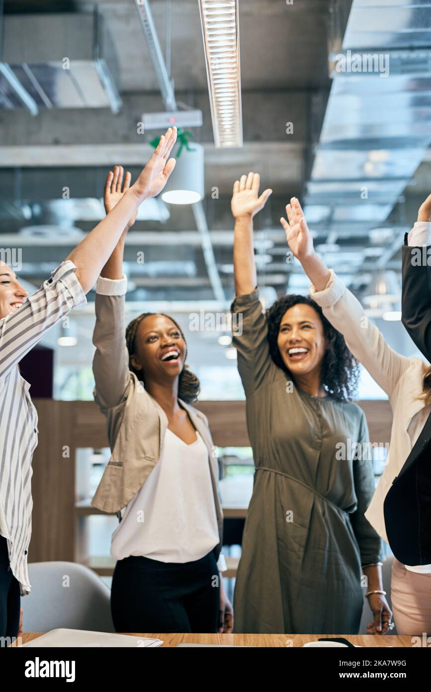 Raise it up top. a group of cheerful young businesspeople stretching ...