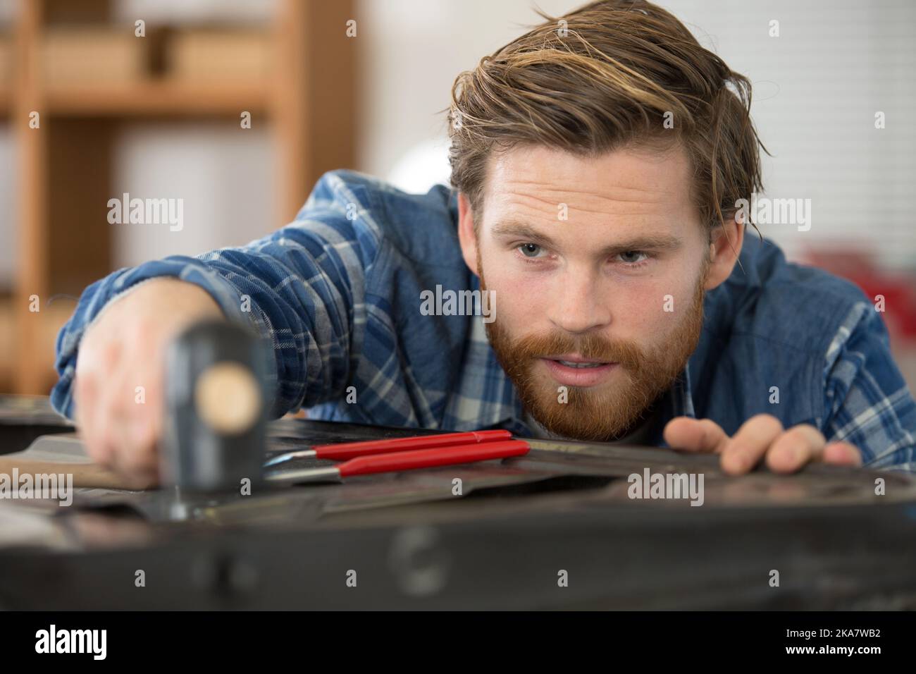 male worker tapping using a hammer Stock Photo - Alamy