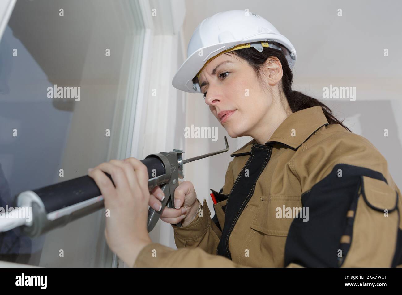 woman window installer applying caulking Stock Photo - Alamy