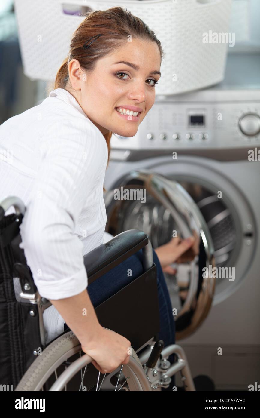 woman in a wheelchair closing the washing machine Stock Photo - Alamy
