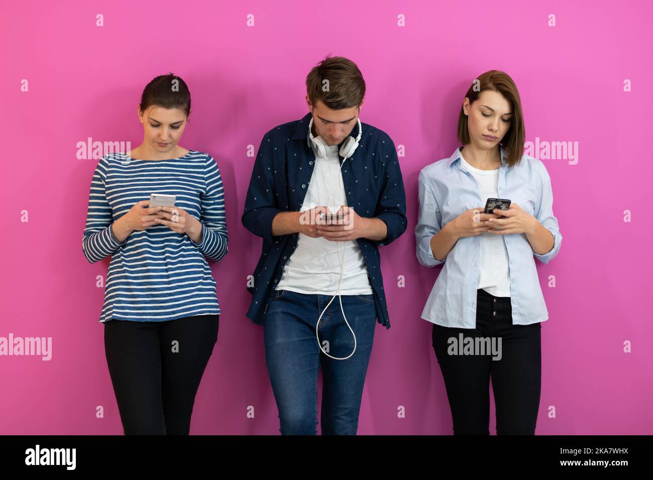 Diverse teenagers using smartphone while posing for a studio photo in ...