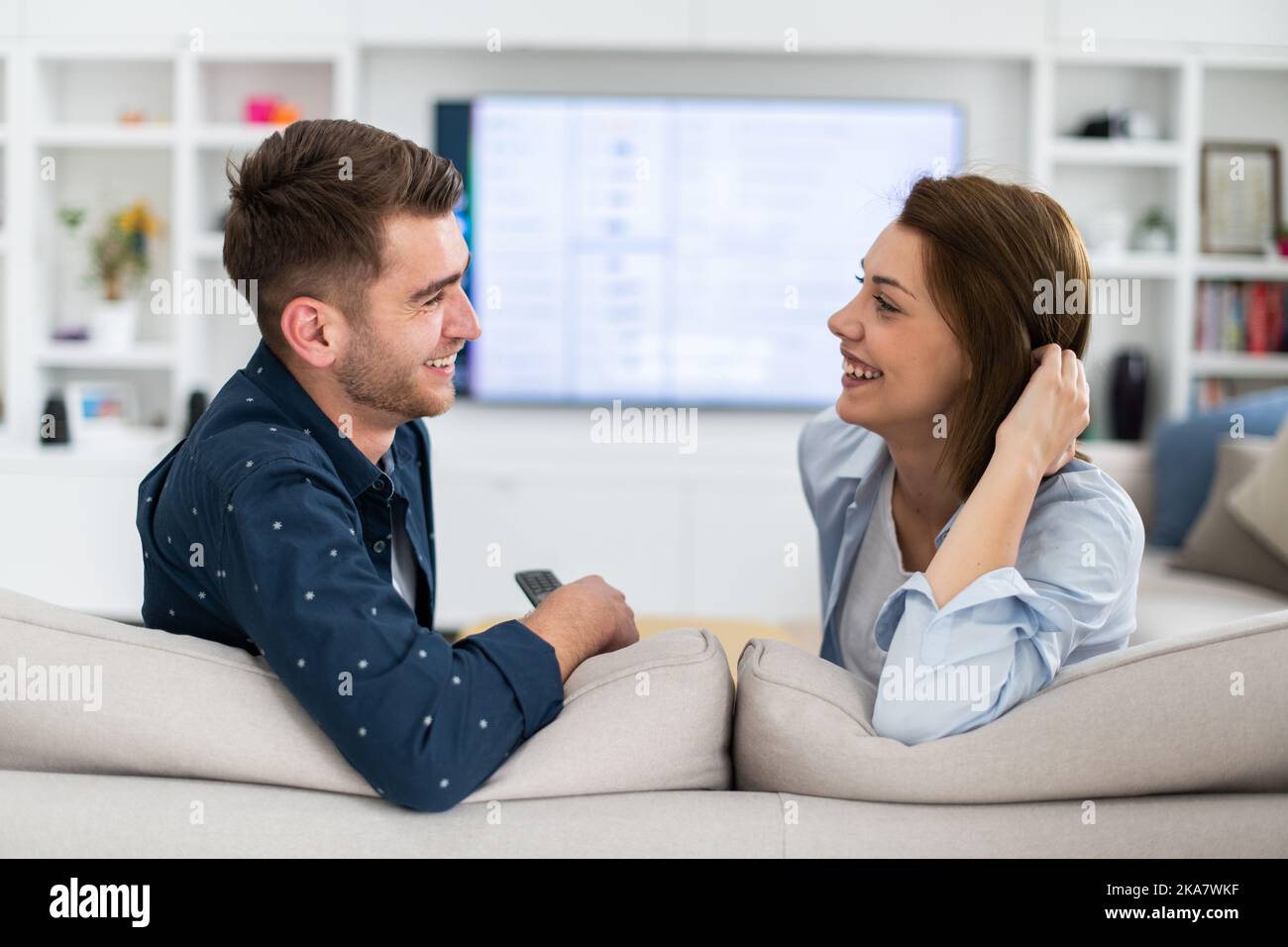 Couple Watches TV together while Sitting on a Couch in the Living Room ...