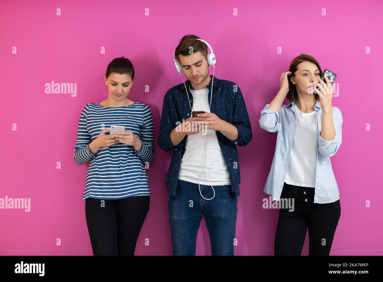 Diverse teenagers using smartphone while posing for a studio photo in ...