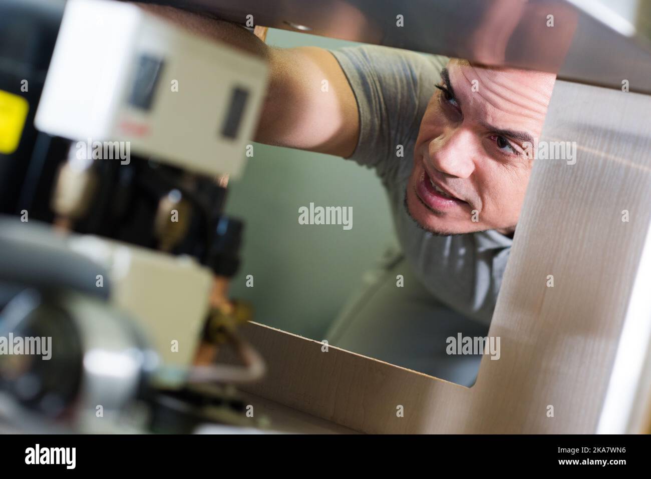 worker inspecting a malfunctioning machine Stock Photo - Alamy