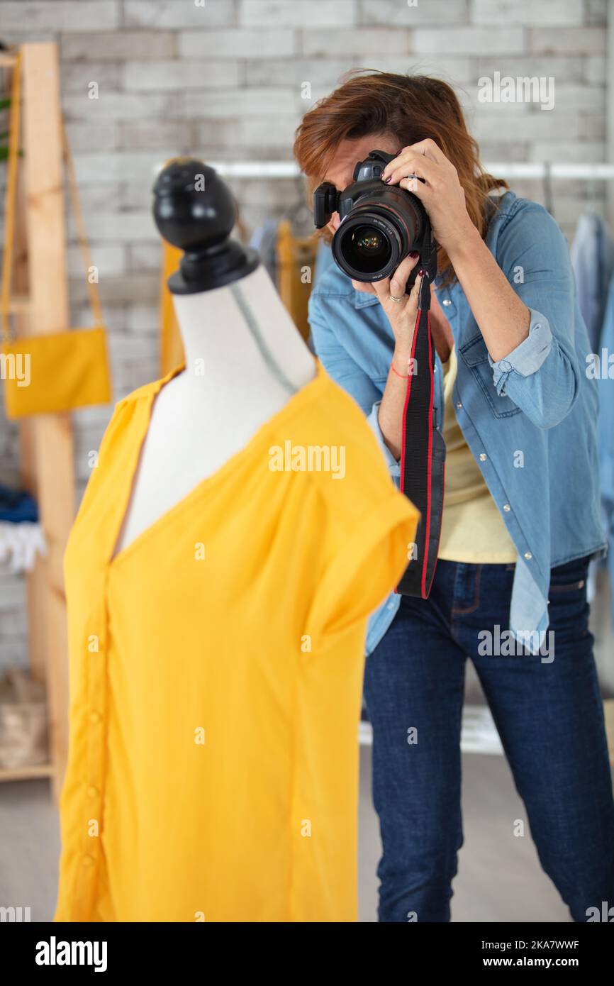female photographer photographing clothes on a mannequin Stock Photo ...