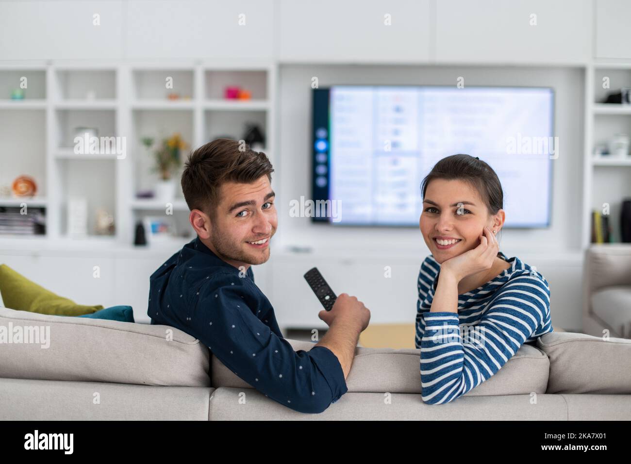 Couple Watches TV together while Sitting on a Couch in the Living Room ...