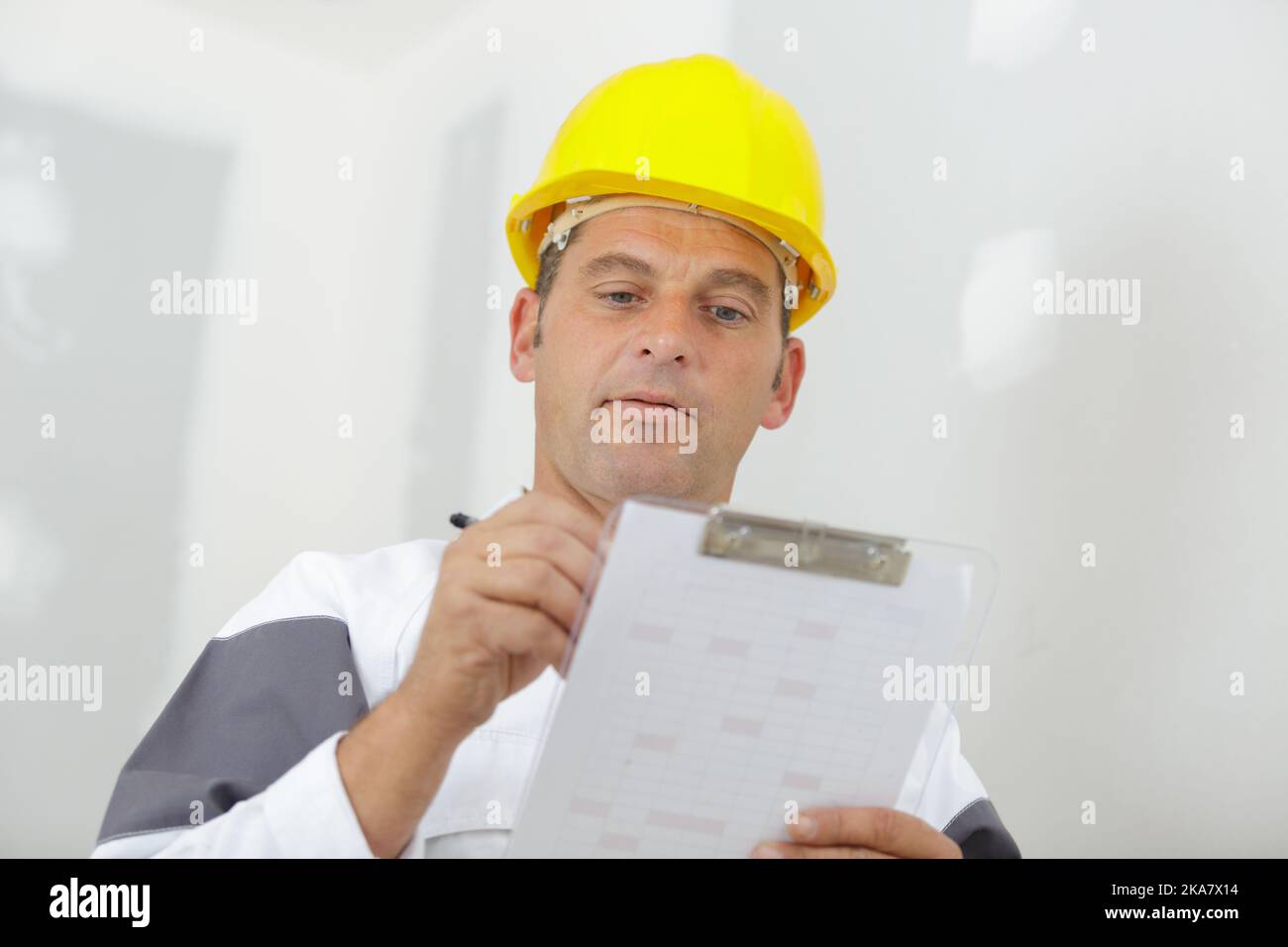 builder writing notes on clipboard Stock Photo - Alamy