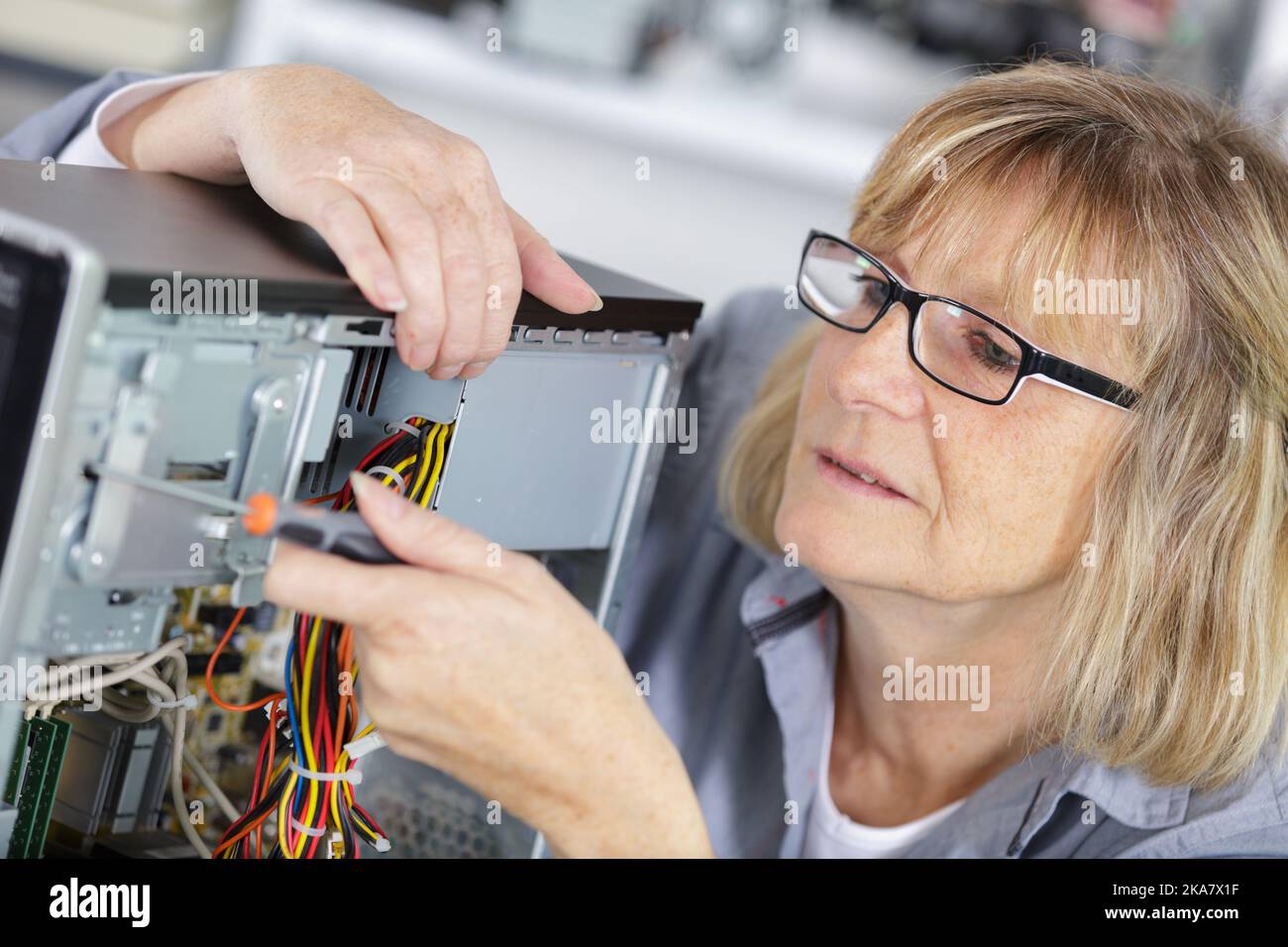 mature female techncian fixing a pc Stock Photo - Alamy