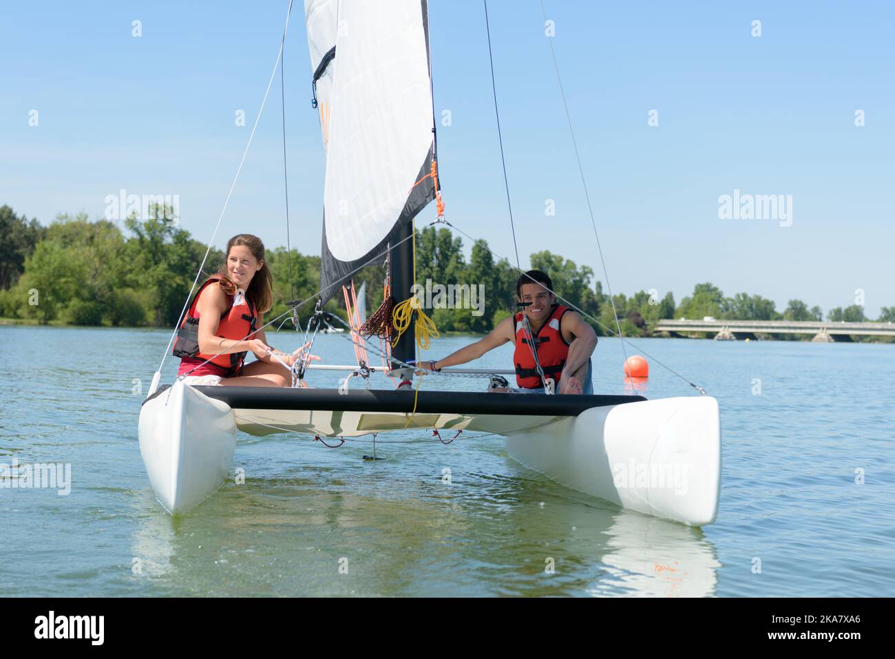 young couple holding ropes on catamaran Stock Photo - Alamy