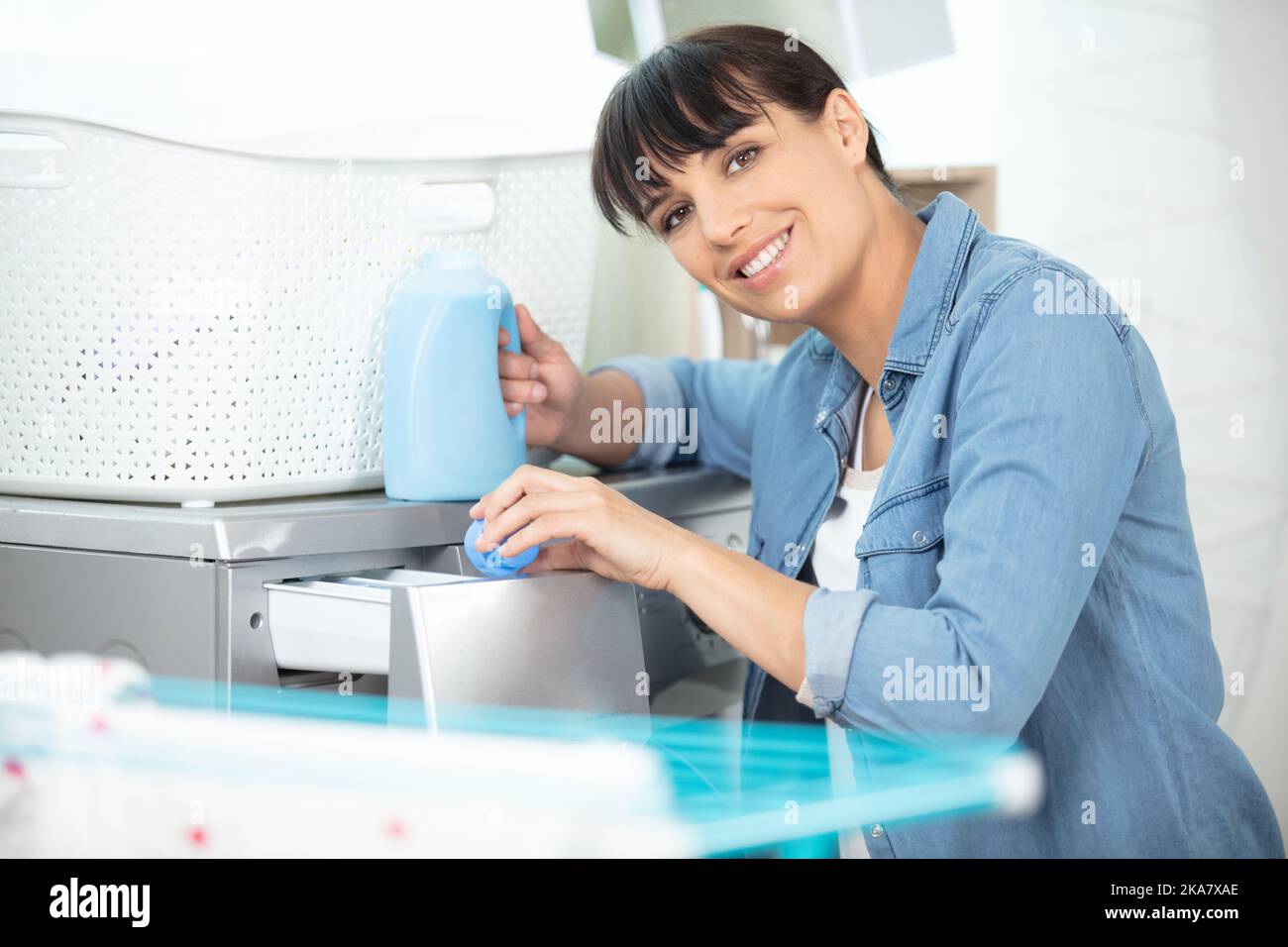 happy woman pouring fabric softener into washing machine Stock Photo ...