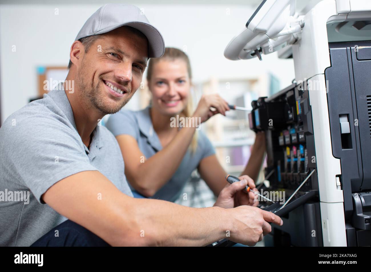 couple of workers fixing a printer Stock Photo - Alamy