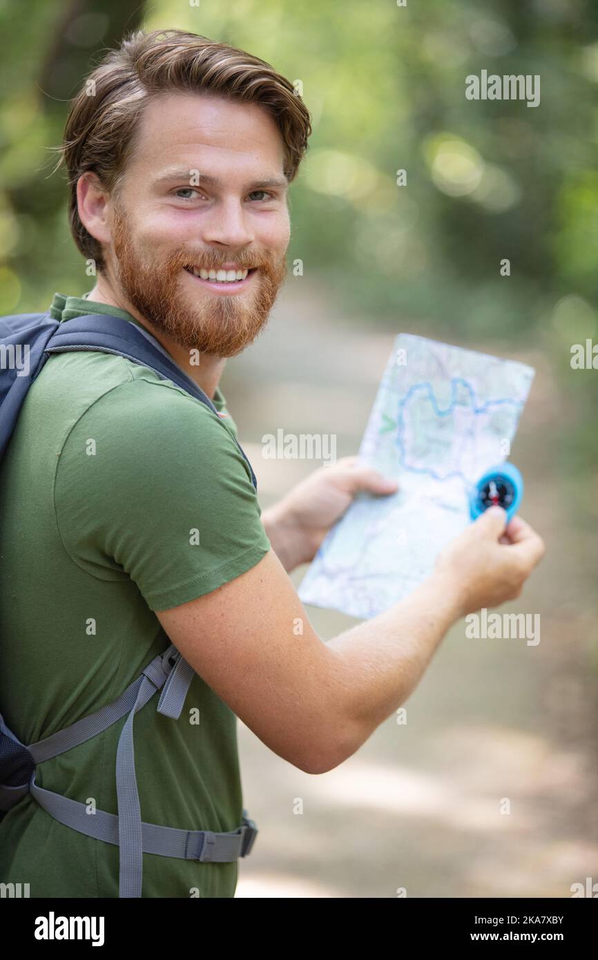 hiker in the forest with a compass and map Stock Photo - Alamy