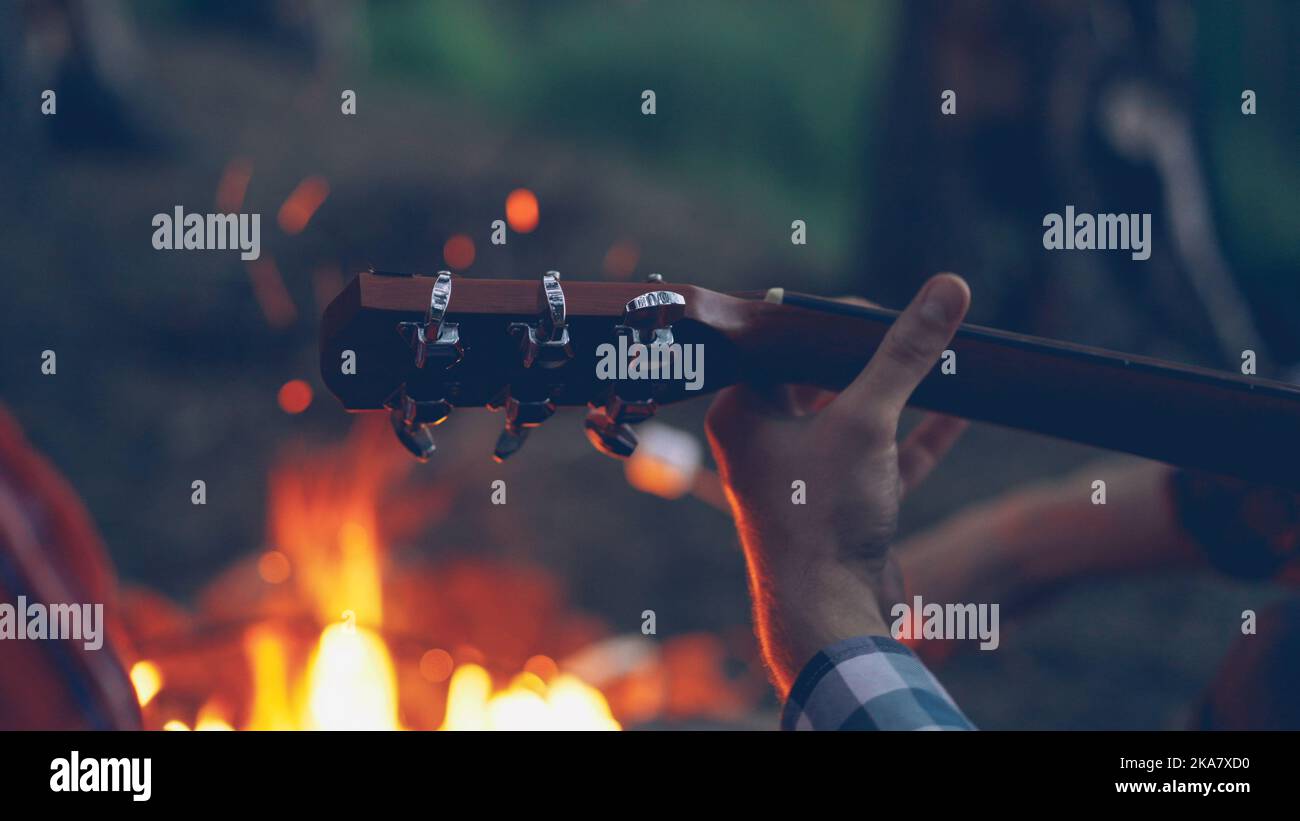 Close-up shot of male tourist's hand playing the guitar during romantic ...