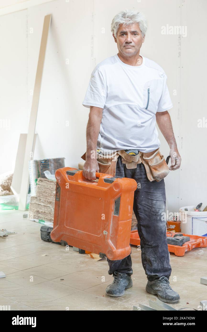Builder carrying plastic tool box Stock Photo - Alamy