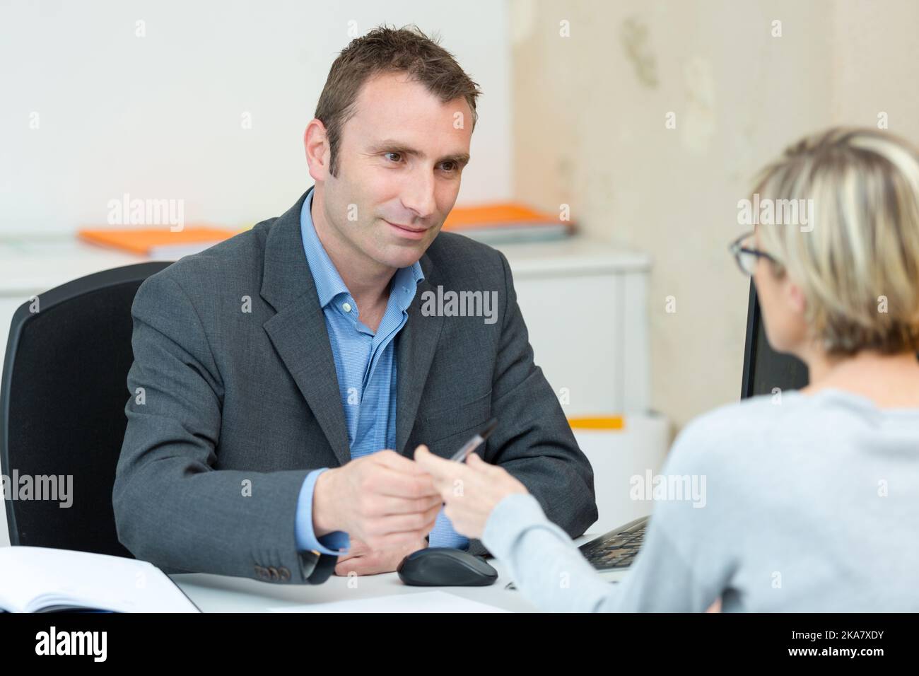 agency worker giving calling card to the client Stock Photo - Alamy