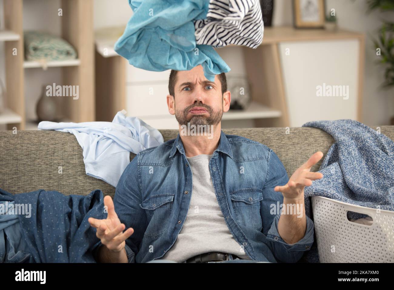 a distraught man with lots of laundry to do Stock Photo - Alamy