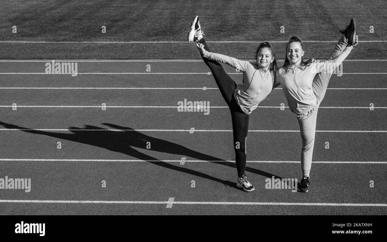 Happy teenage gymnasts do vertical splits holding legs at athletics ...