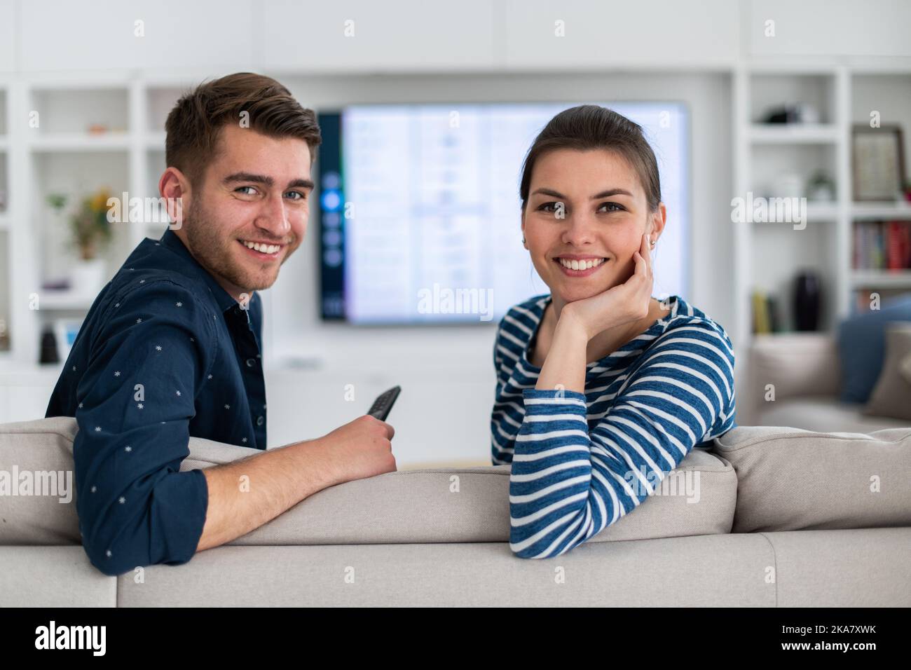 Couple Watches TV together while Sitting on a Couch in the Living Room ...