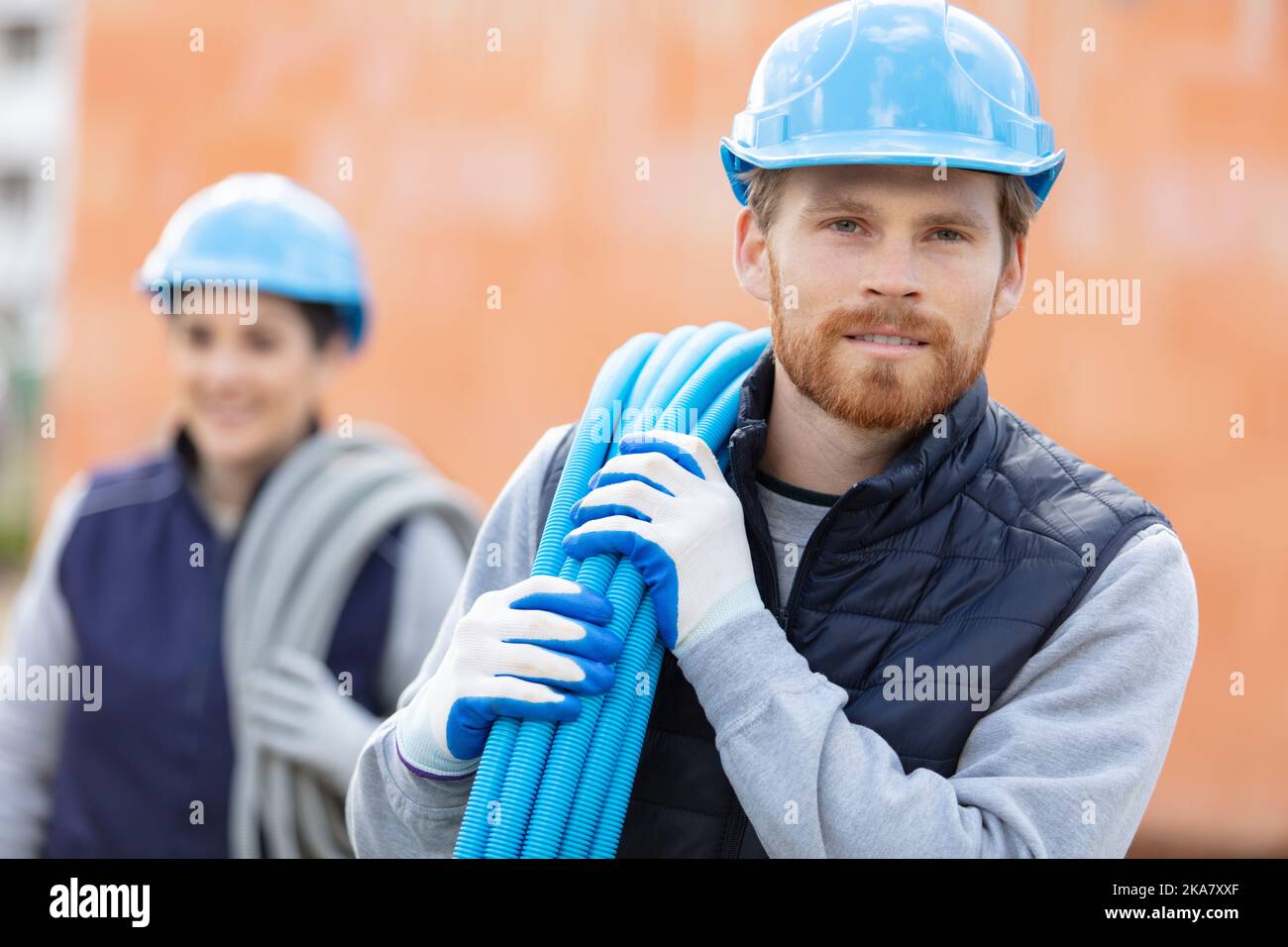 construction worker on site holding pipe Stock Photo - Alamy