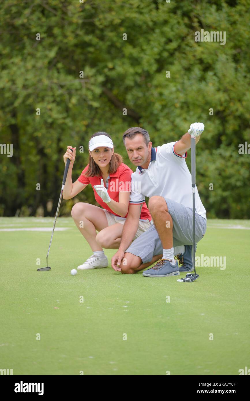 golfing couple hugging on a course Stock Photo - Alamy