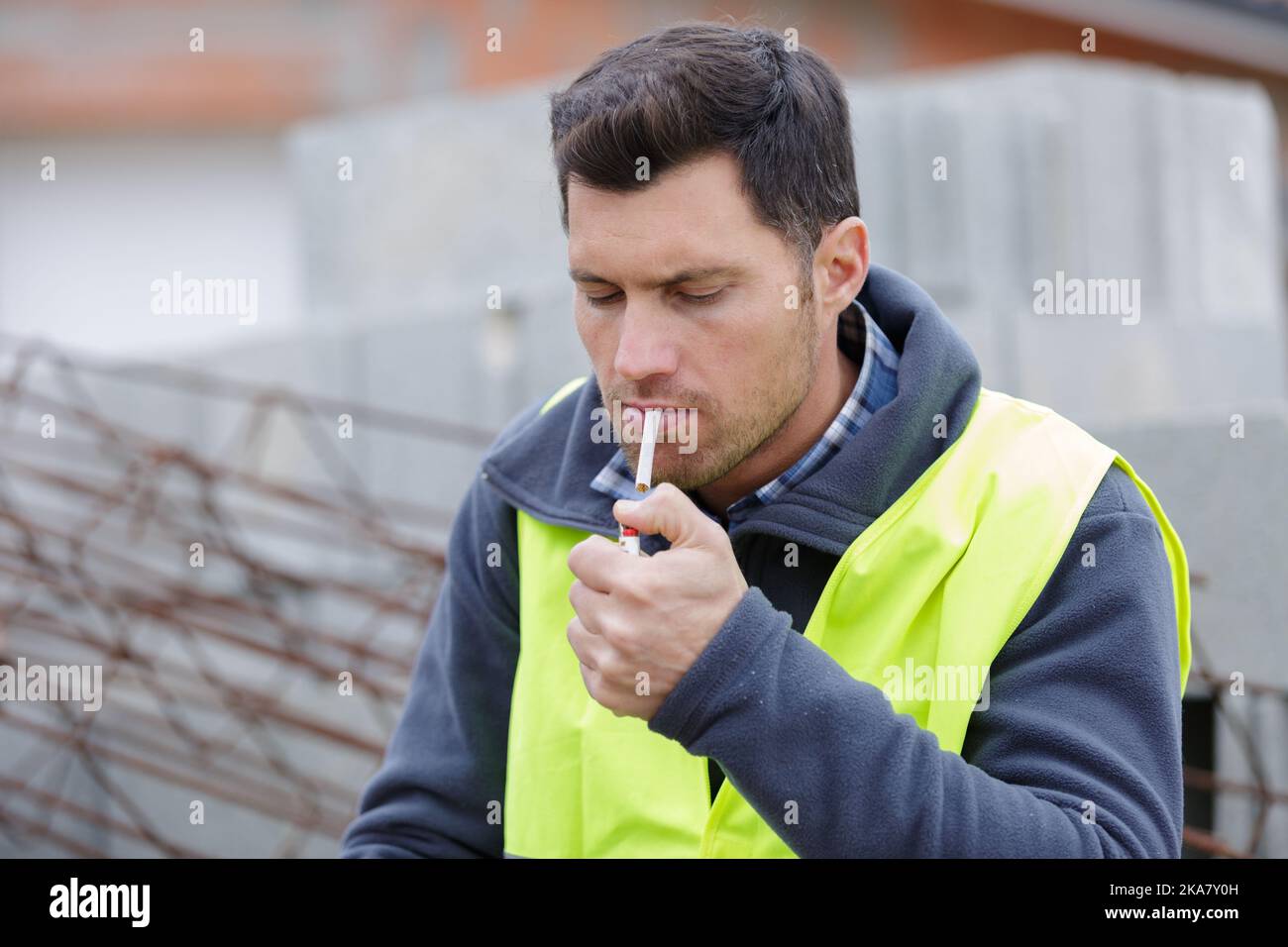 a construction worker is smoking Stock Photo - Alamy