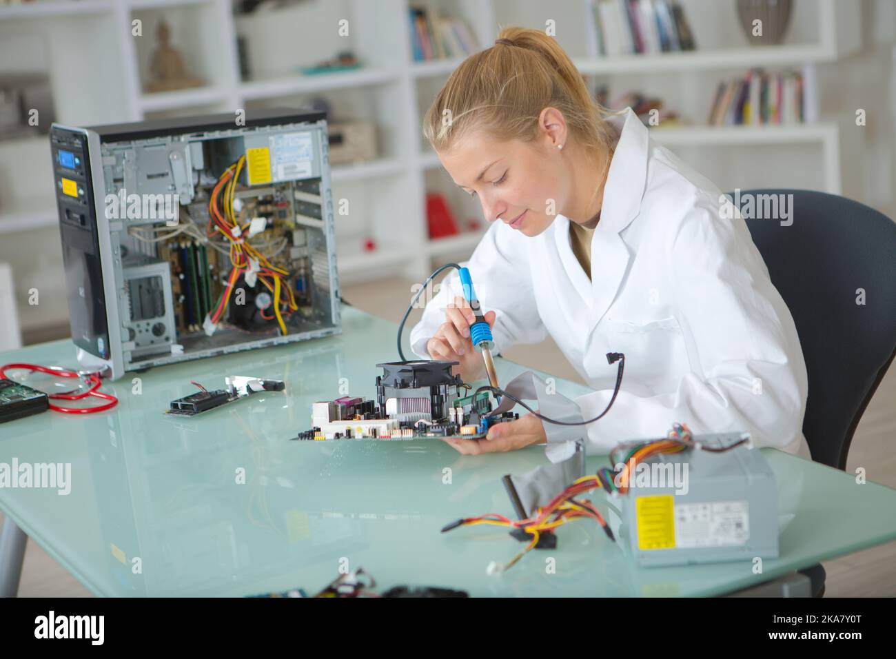 female pc technician soldering a chip from a desktop computer Stock ...