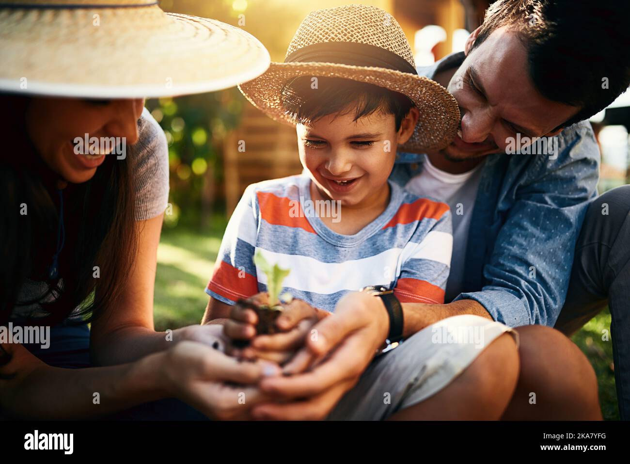 Teach your kids to love nature. a family gardening together in their ...