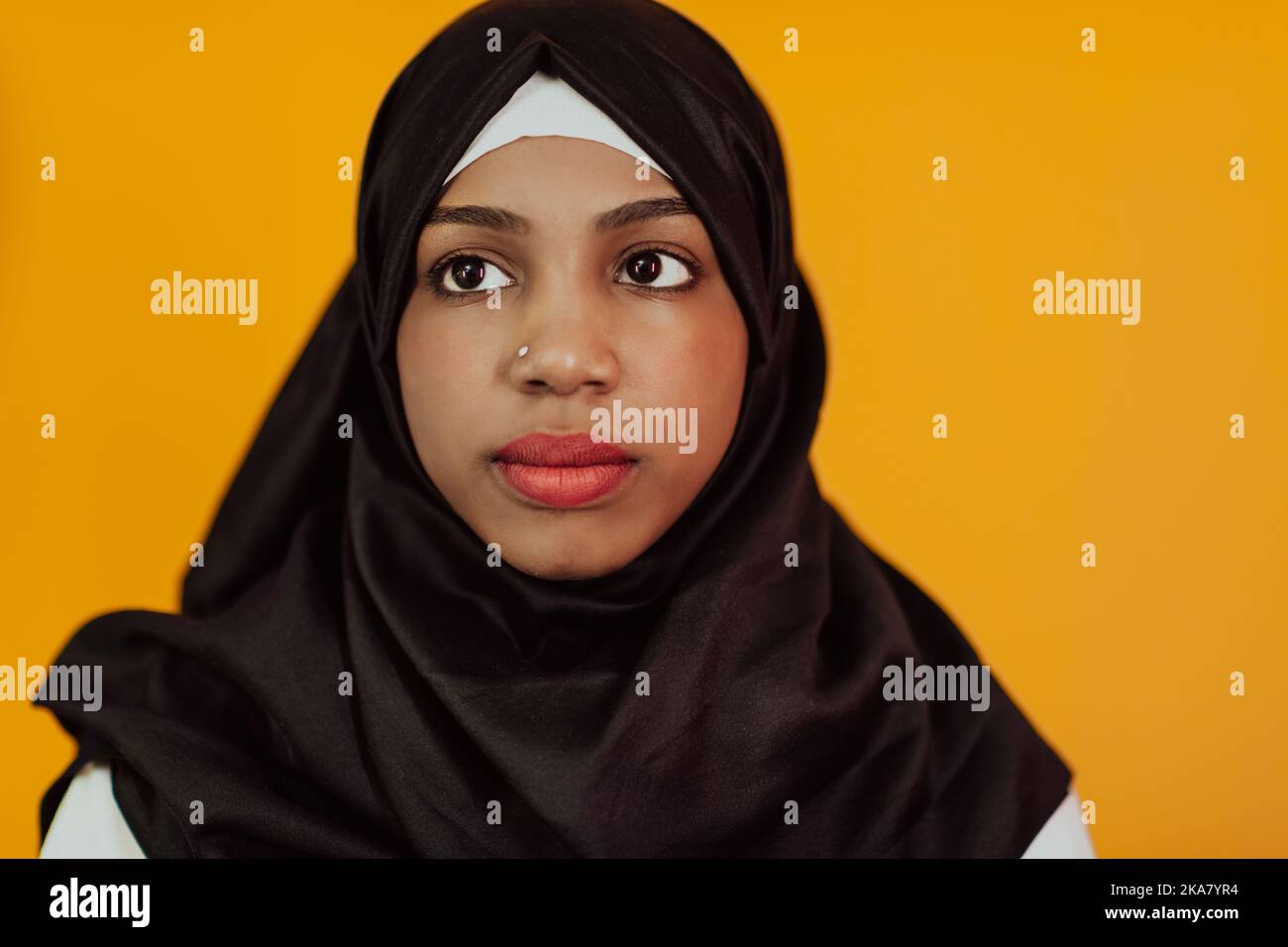 Muslim woman with a beautiful smile wearing a hijab poses in the studio ...