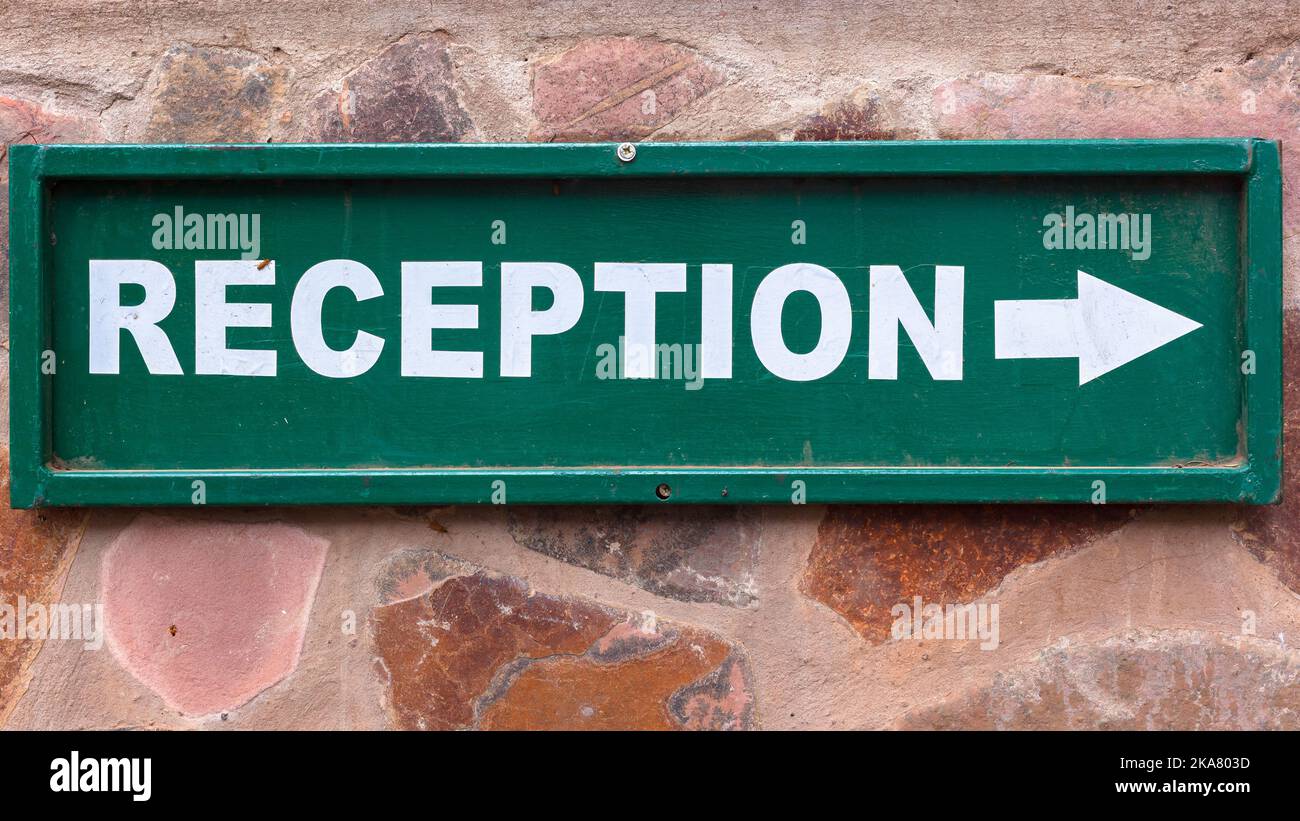 Outdoors green signboard white wording for reception directions closeup ...