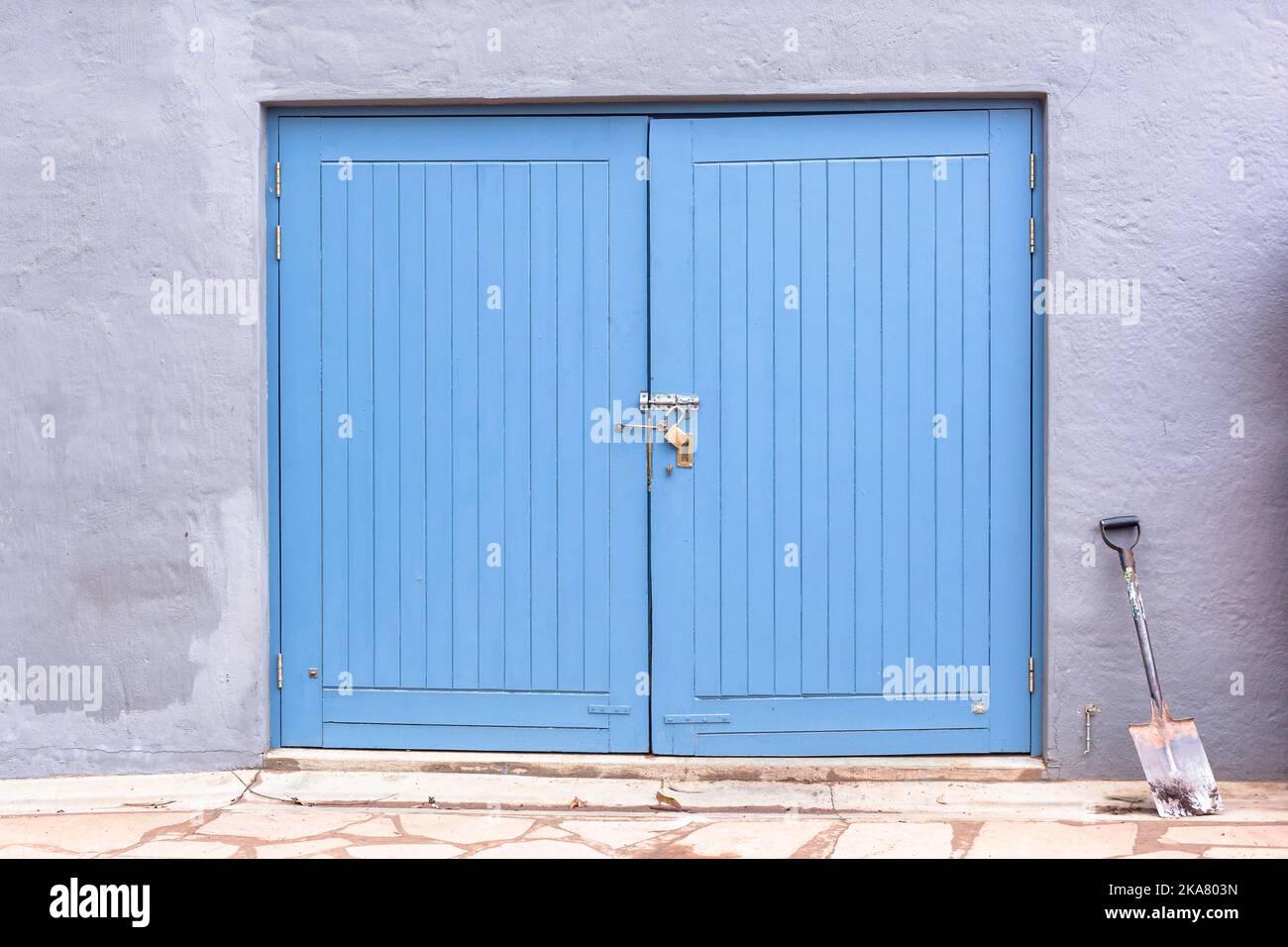 Workshop large double blue painted wood doors closed with padlock ...