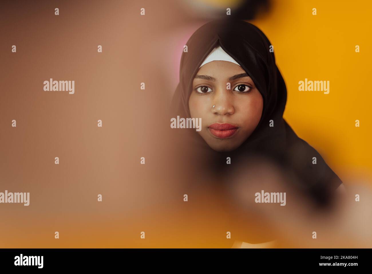 Muslim woman with a beautiful smile wearing a hijab poses in the studio ...