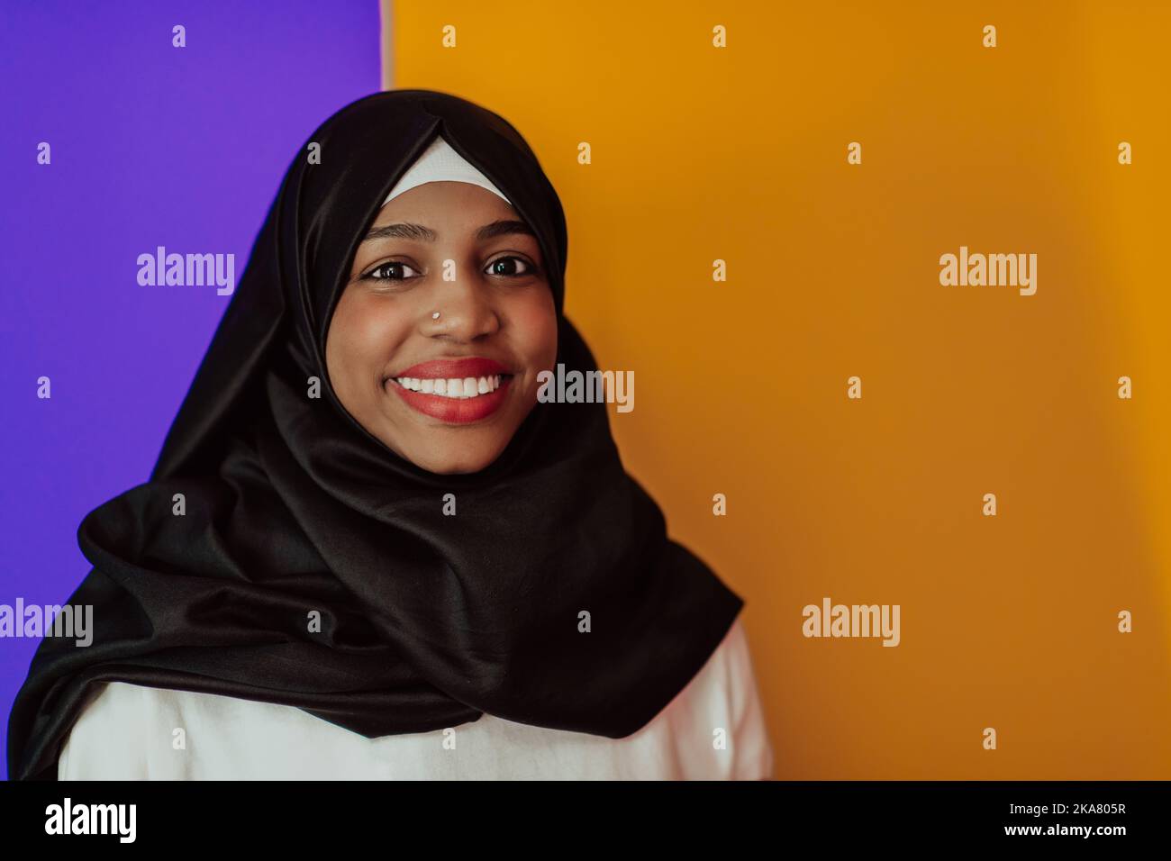 Muslim woman with a beautiful smile wearing a hijab poses in the studio ...