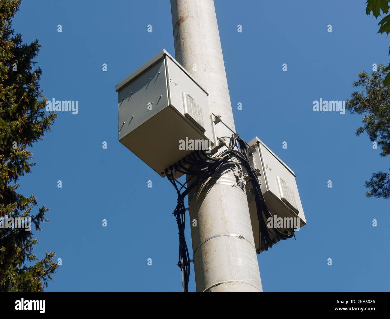 Cell tower with two instrument boxes on blue sky Stock Photo - Alamy