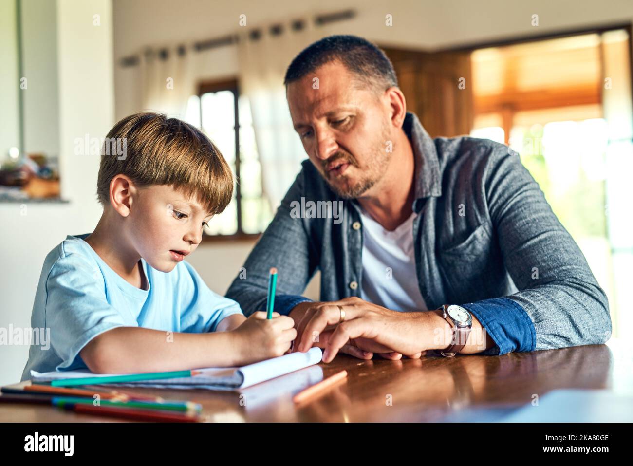 Never to busy to help his boy with homework. a father helping his son ...