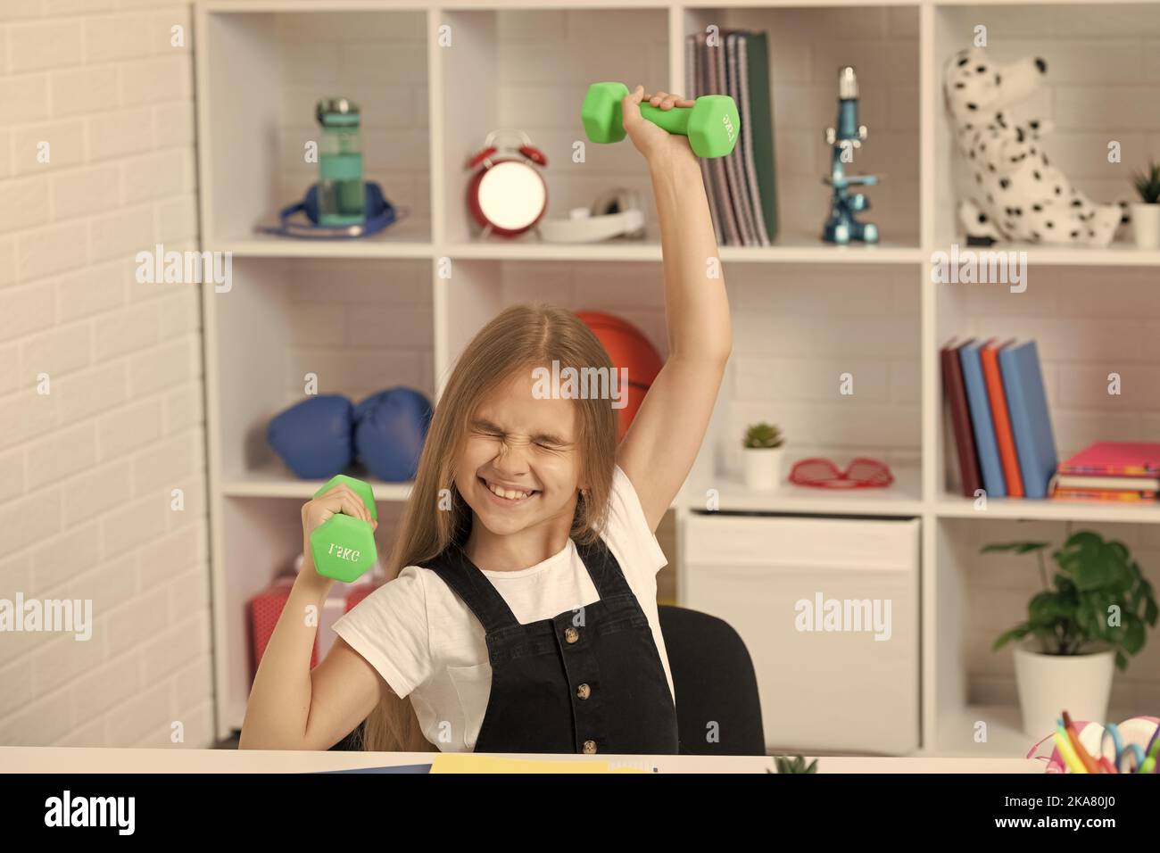 strong child hold barbells in school classroom Stock Photo - Alamy